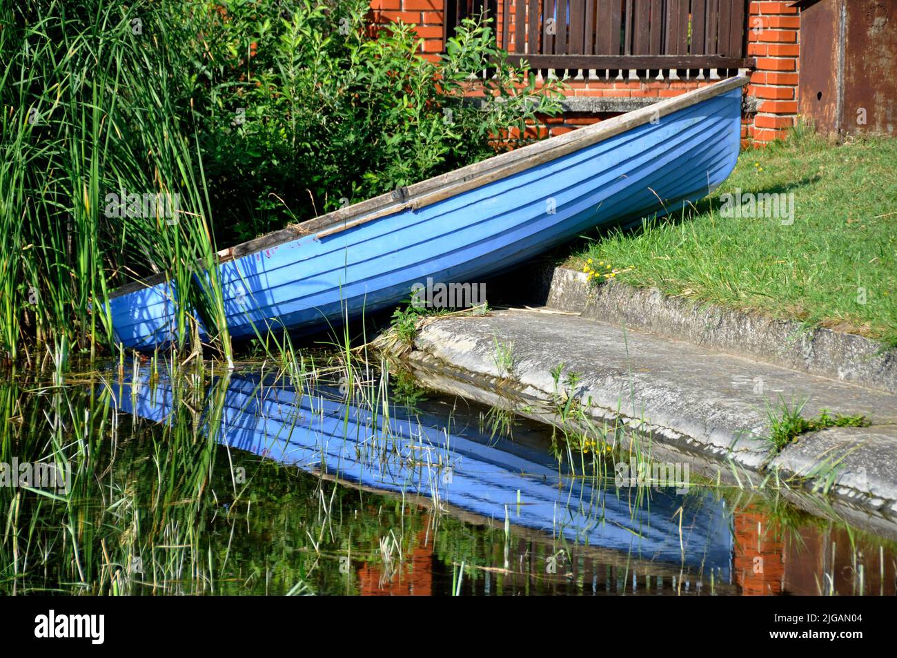 blue fishing boat reflection in the water Stock Photo - Alamy