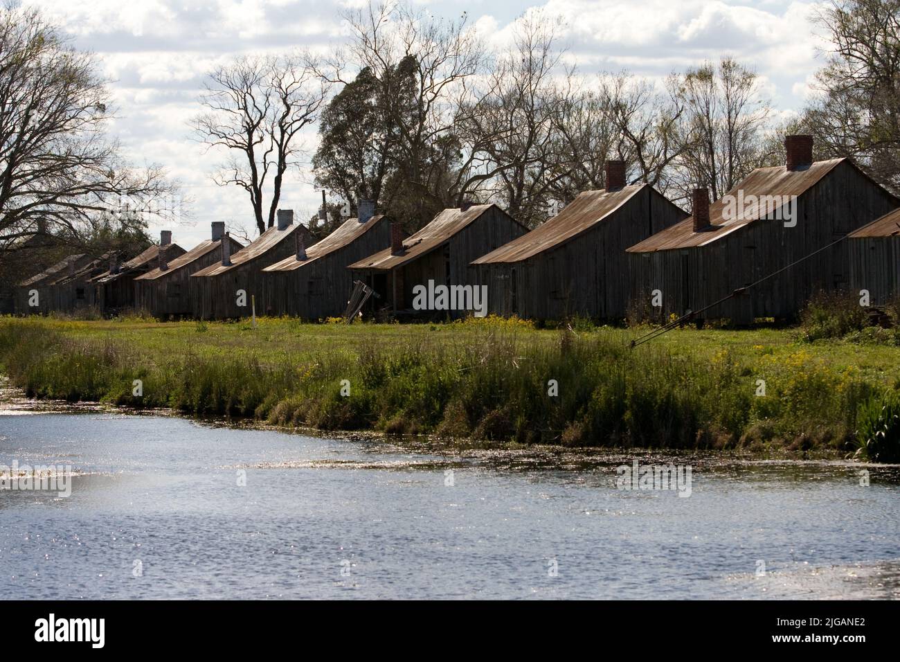 A scenic view of old huts built along the river in a rural area in ...