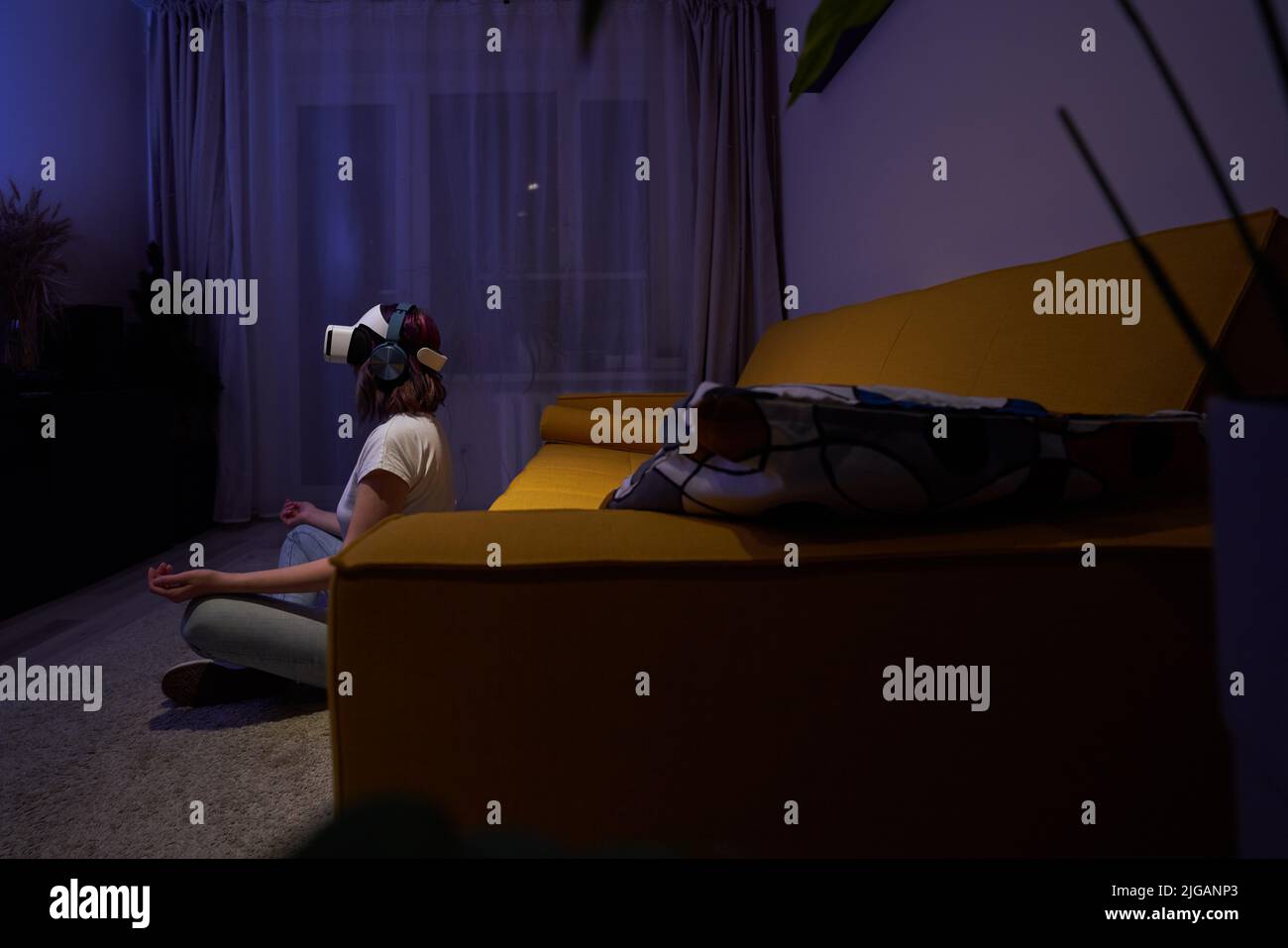 Woman uses virtual reality glasses to relax and meditate. Concept of ...