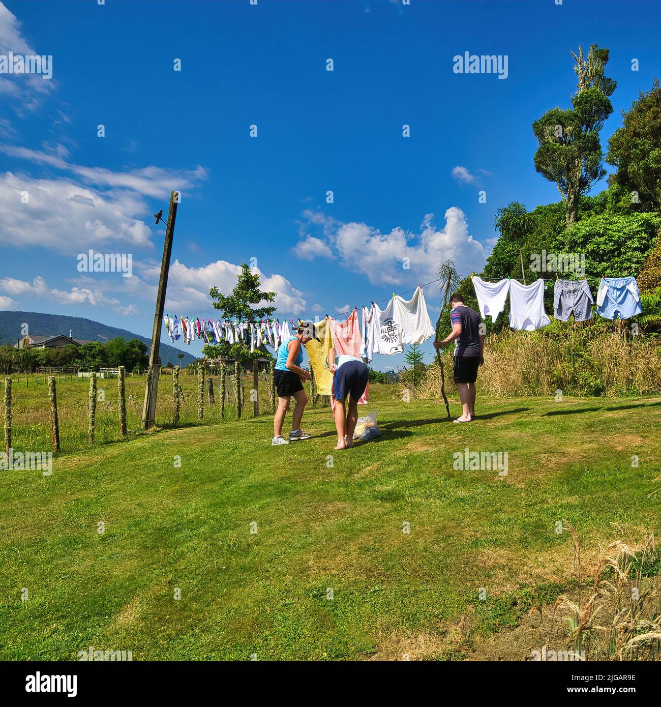 Mum and adult boys hanging out the washing on holidays in NZ Stock ...