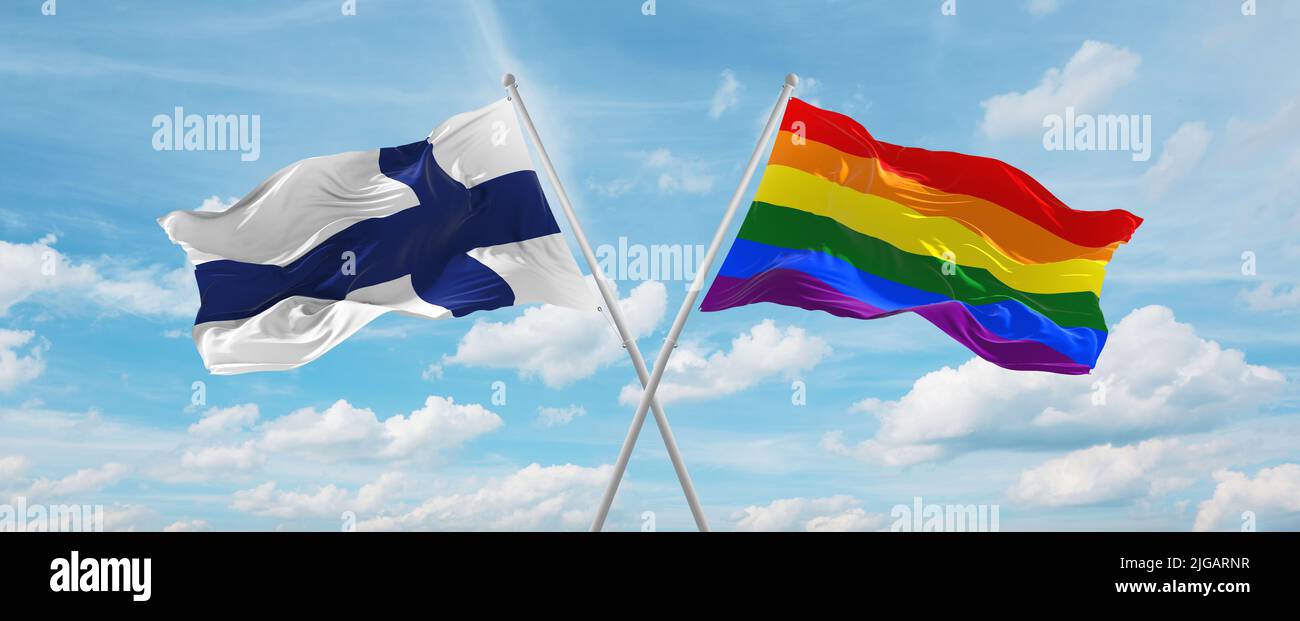 two crossed flags LGBT Pride and finland waving in wind at cloudy sky ...