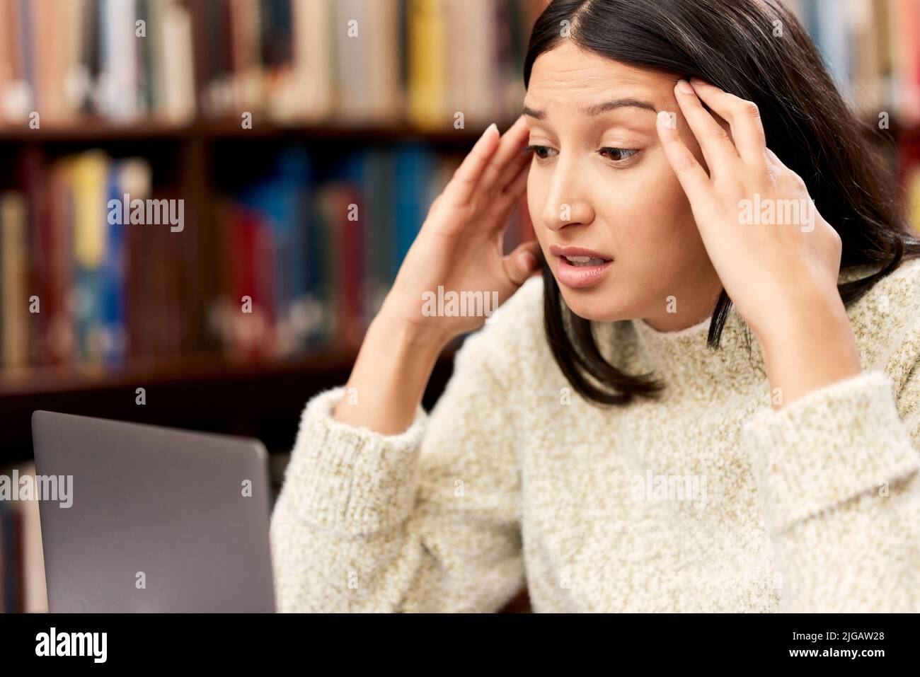 So much work to be done. a young female student looking unhappy while ...