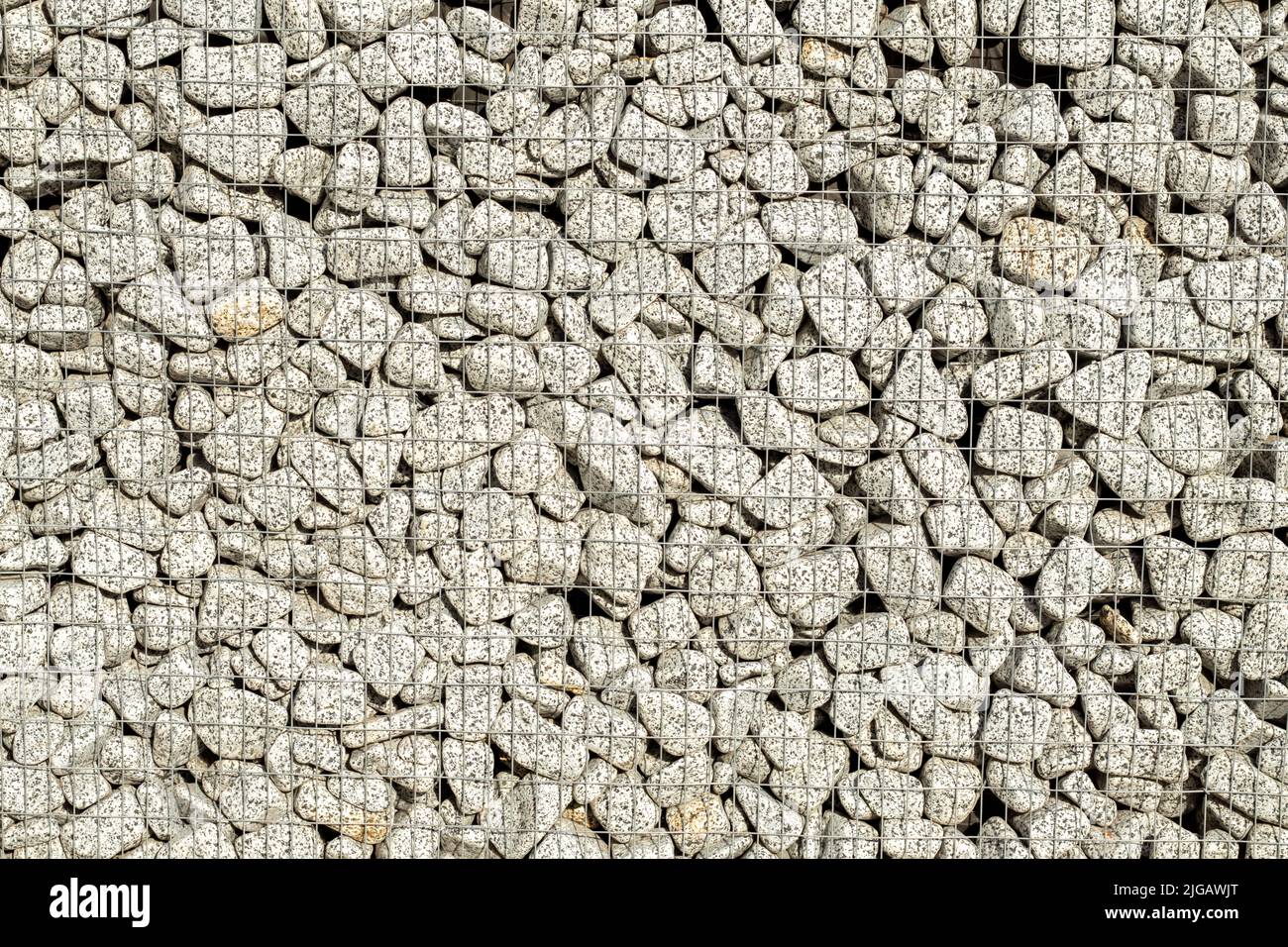 Stone wall in wire frame. Textured background of a stone wall with iron ...
