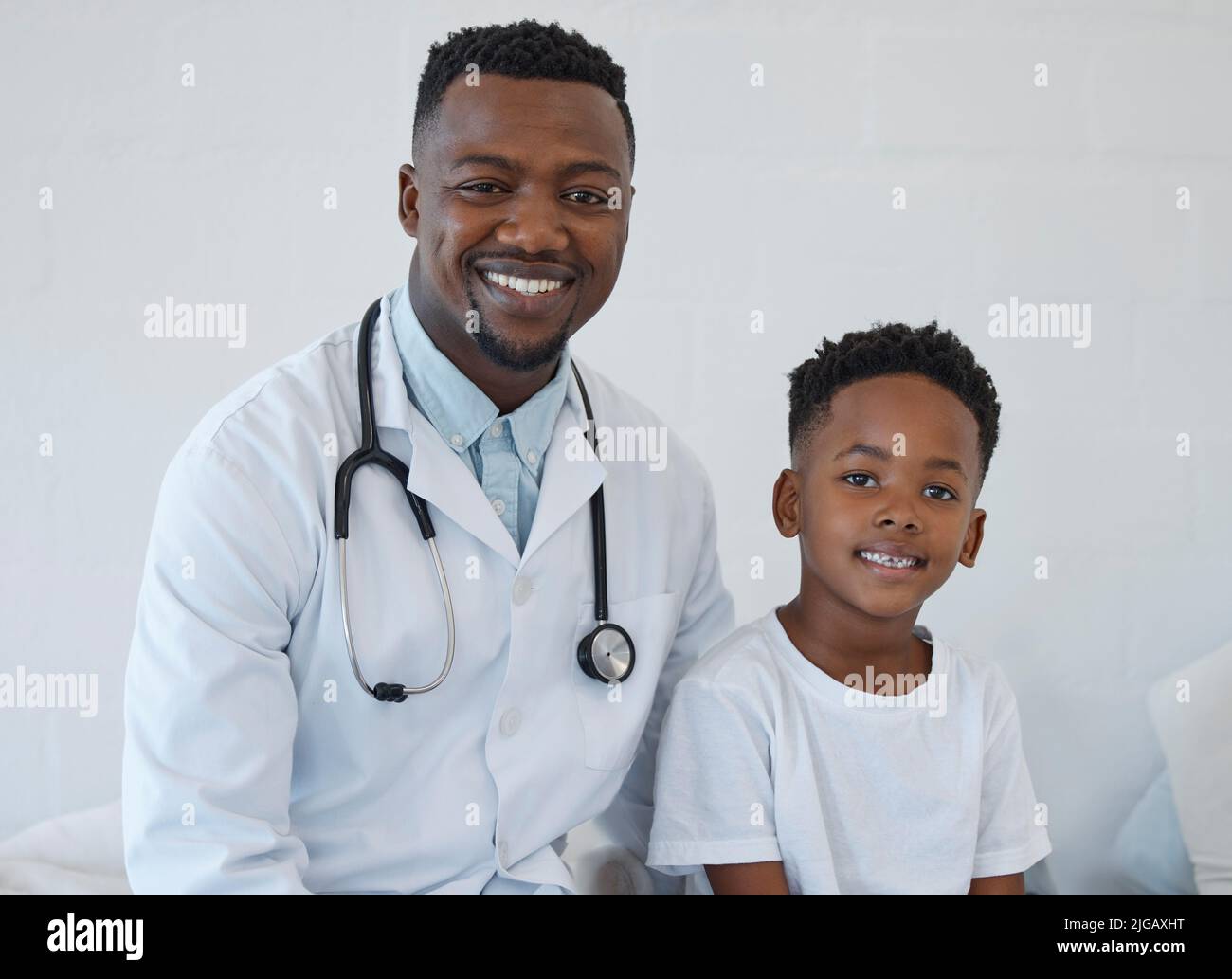 Hes all better. a young male doctor having a checkup with a little boy ...