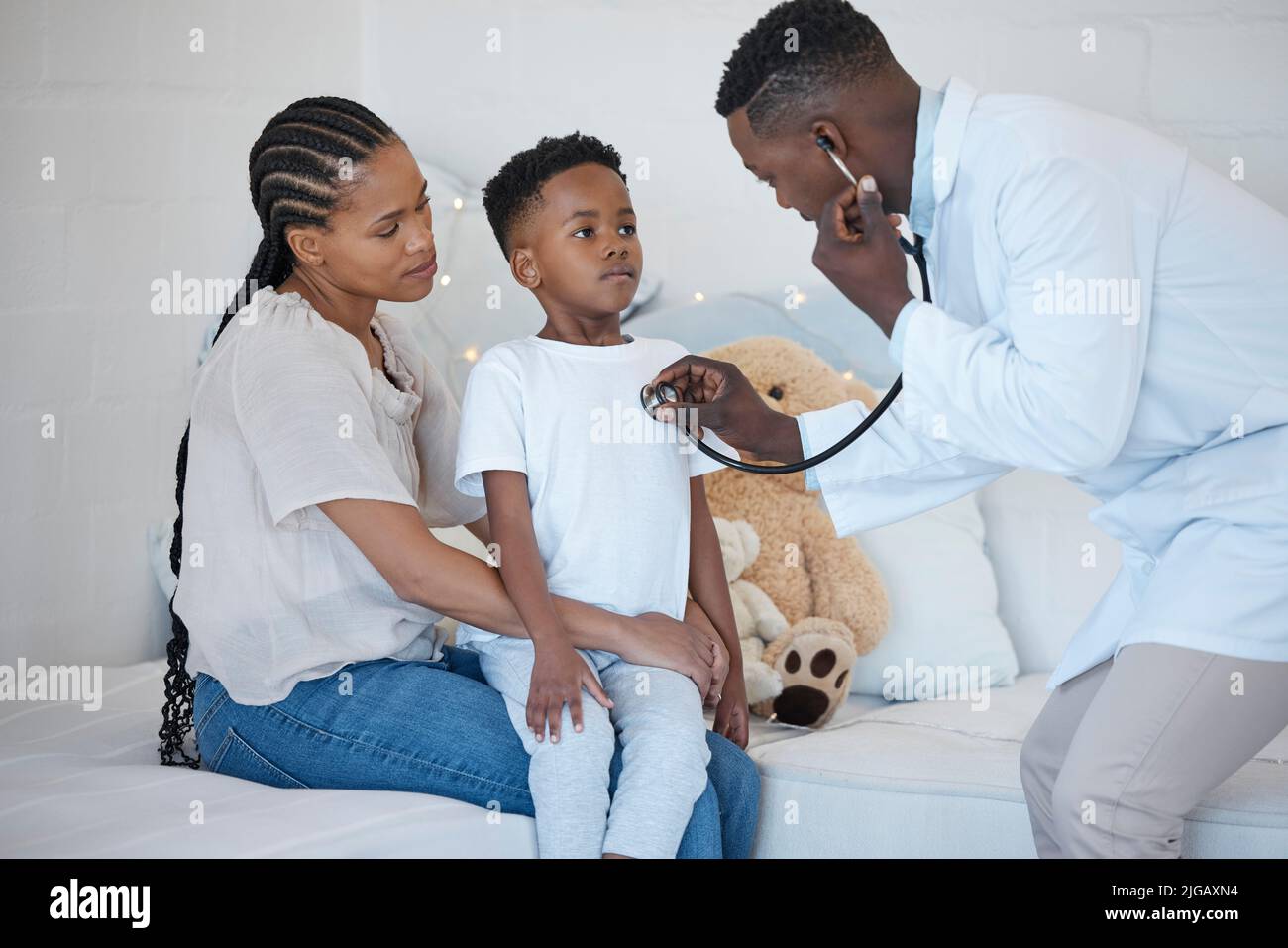 Take a deep breath in. a young male doctor examining a patient with a ...