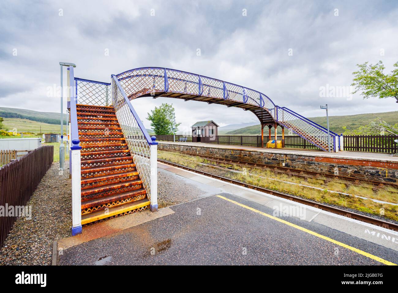 The rusty pedestrian footbridge over the tracks at the railway station ...