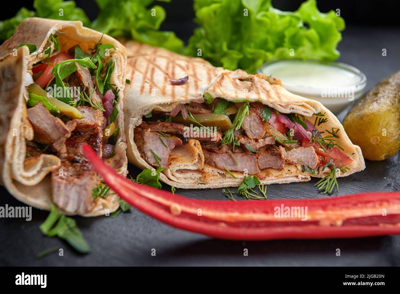 Shawarma in Arabic, with sauce and spices. studio light Stock Photo - Alamy