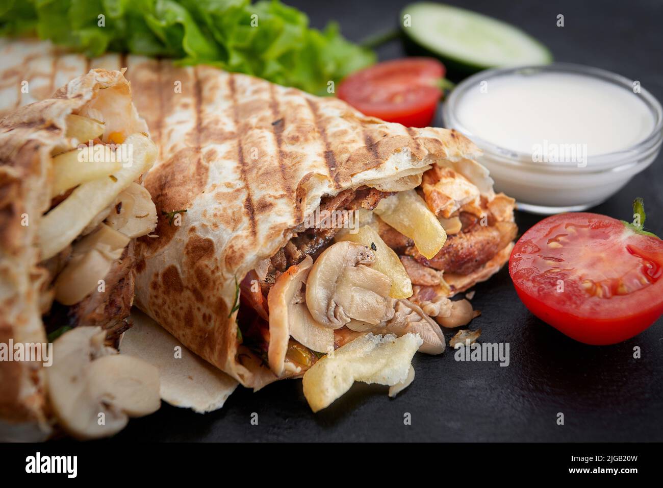 Shawarma with pork, mushrooms, potatoes and sauce, close-up Stock Photo ...