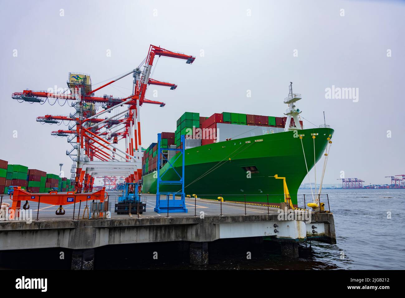 Industrial cranes and a large ship near the container wharf cloudy day ...