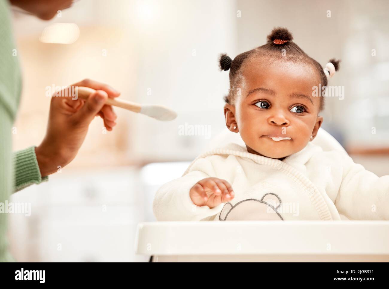 Time for foodies. an adorable little girl being fed by her mother in ...