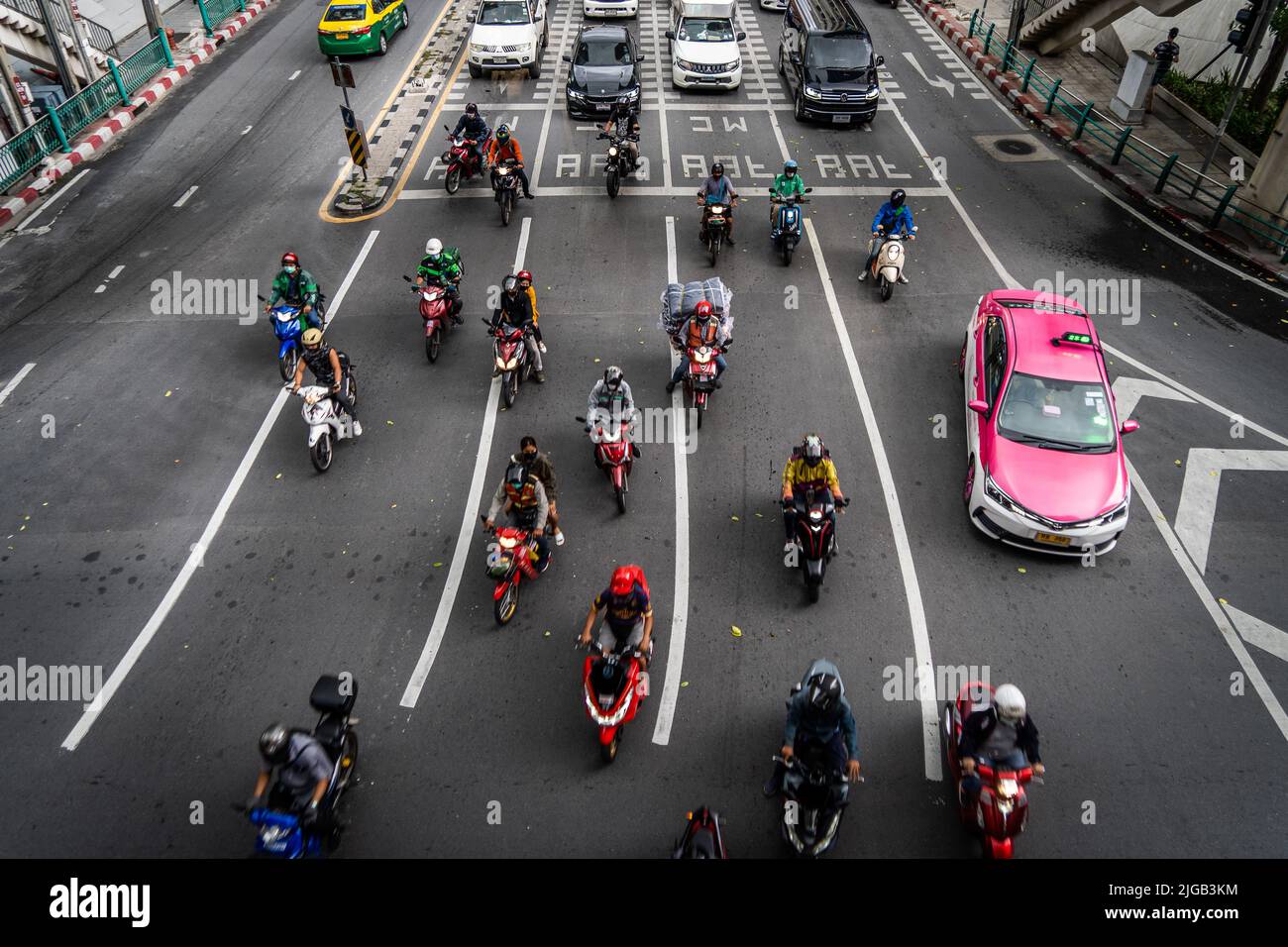 Motorcycles carrying passengers and food deliveries take off in a busy ...