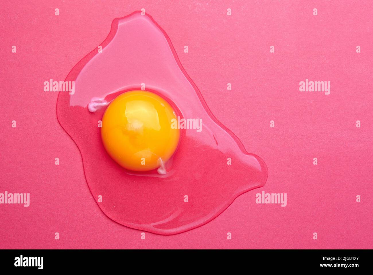 Raw egg on a red background Stock Photo - Alamy