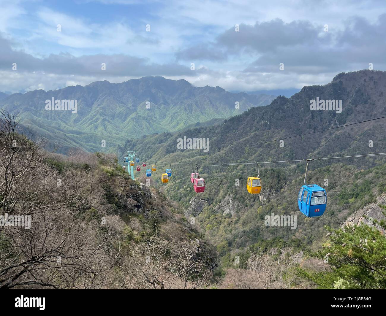 A scenic view of a ropeway with colorful cabins in a mountainous ...