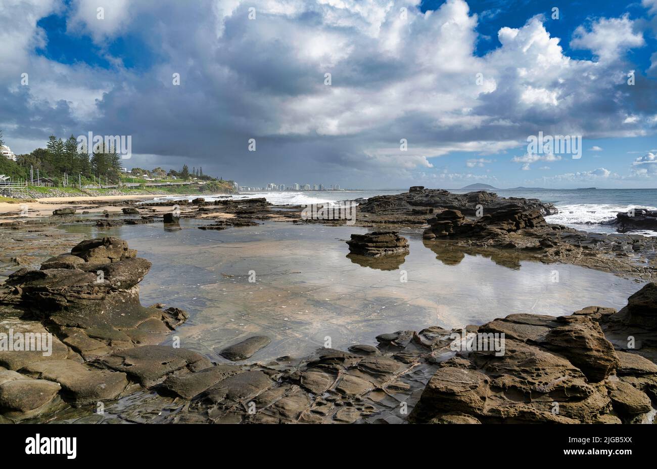An aerial view of rocky beach in background of growing trees in ...