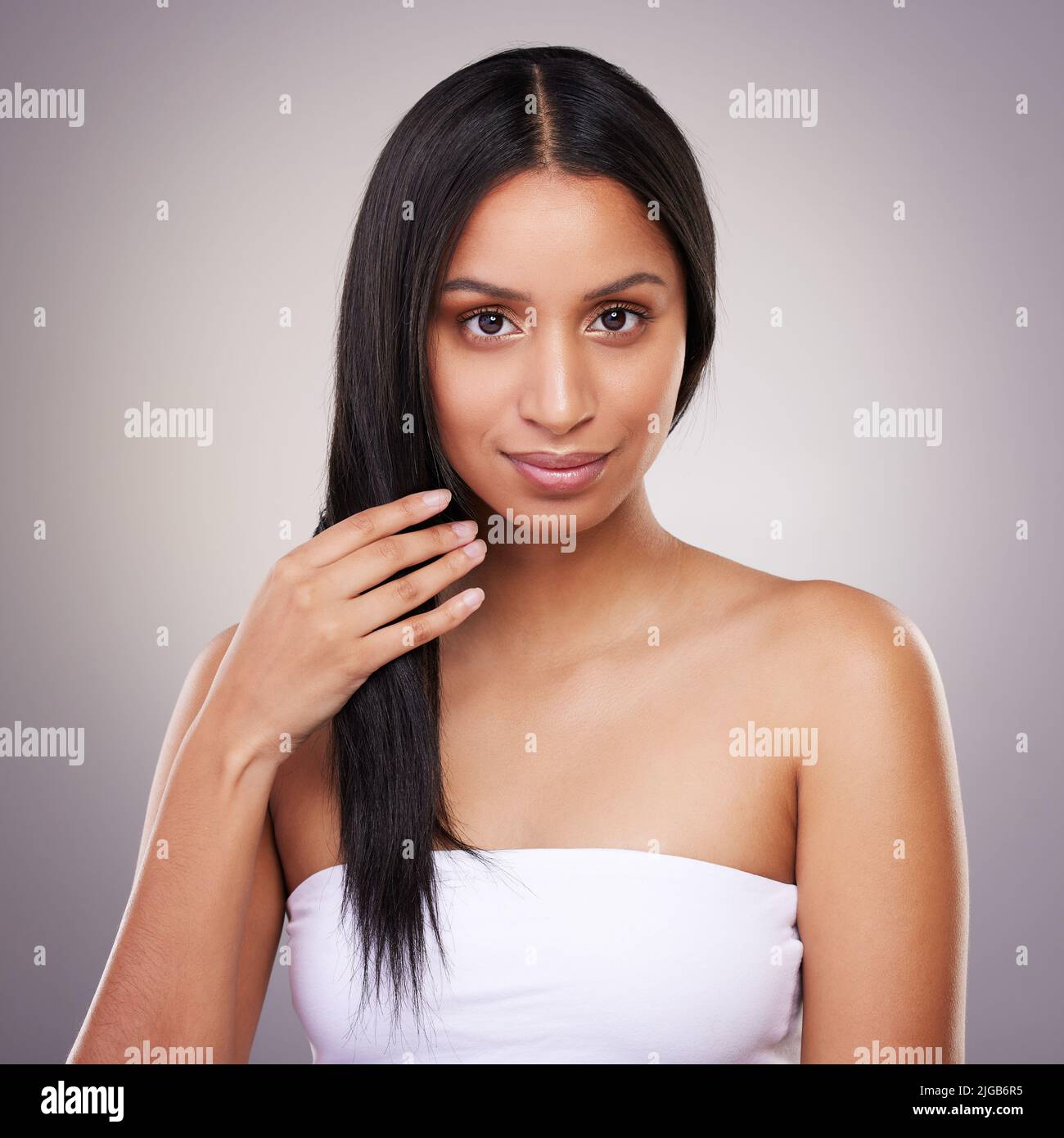 I love the feeling of clean hair. an attractive young woman holding her ...