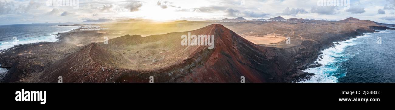 aerial panorama view on volcano and mountains on coast with ocean waves ...