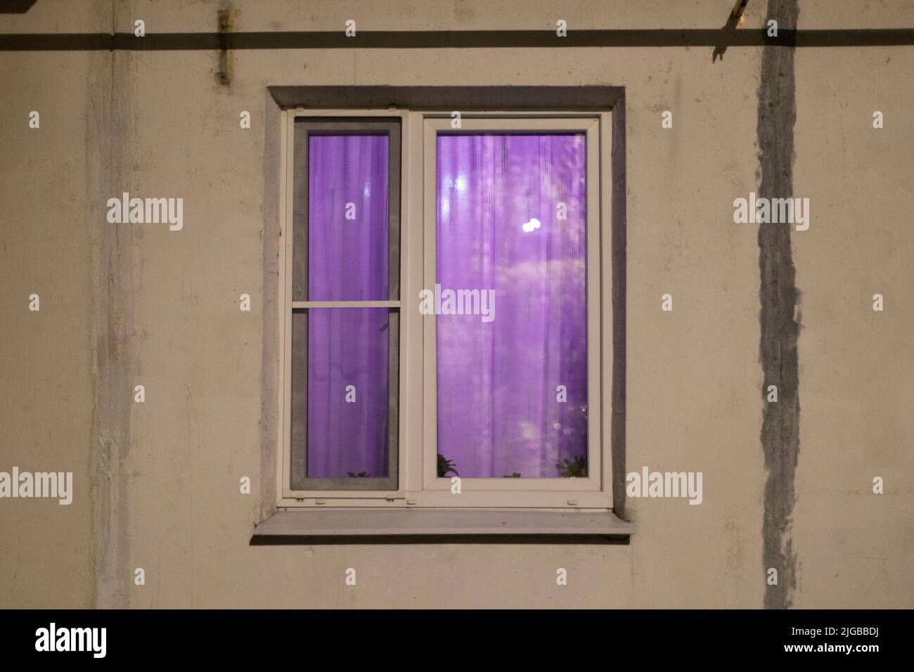 Window in building. Purple light in white window. Details of building ...