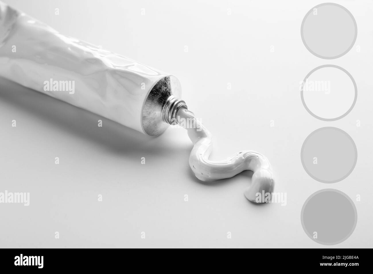 Tube with squeezed paste on white background. Different color patterns ...