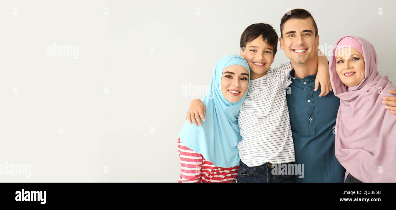 Portrait of happy Muslim family on light background with space for text ...