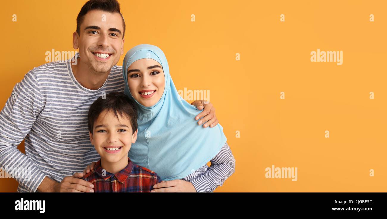 Portrait of happy Muslim family on orange background with space for ...