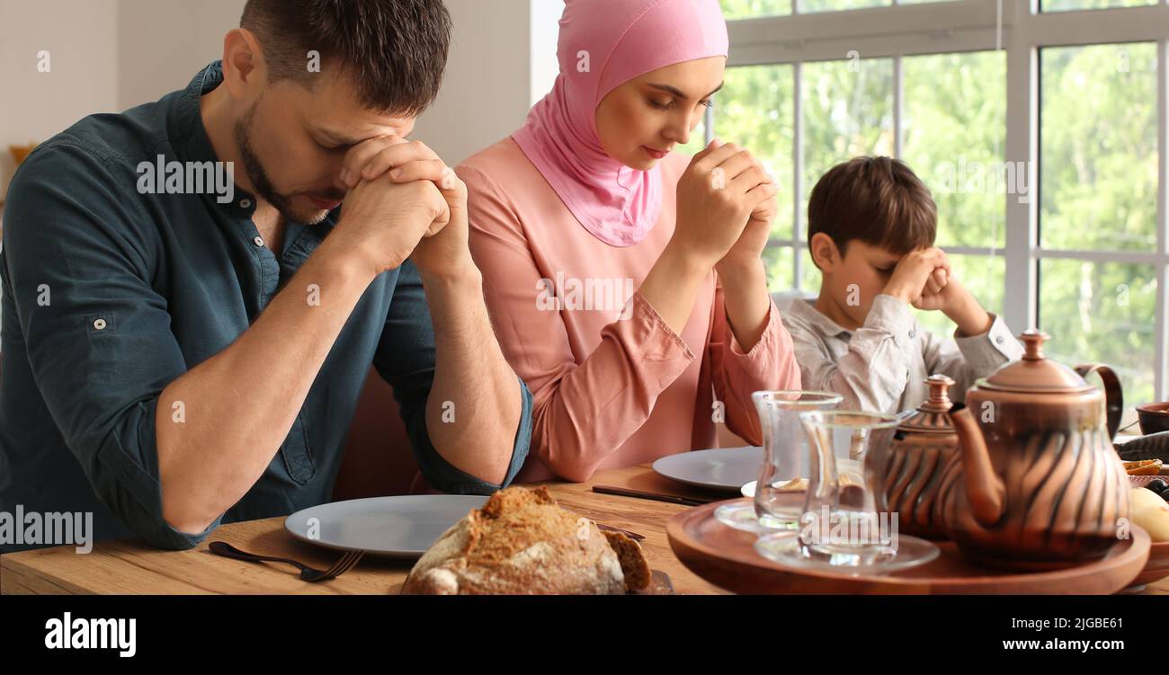 Muslim family praying together before breakfast. Celebration of Eid al ...
