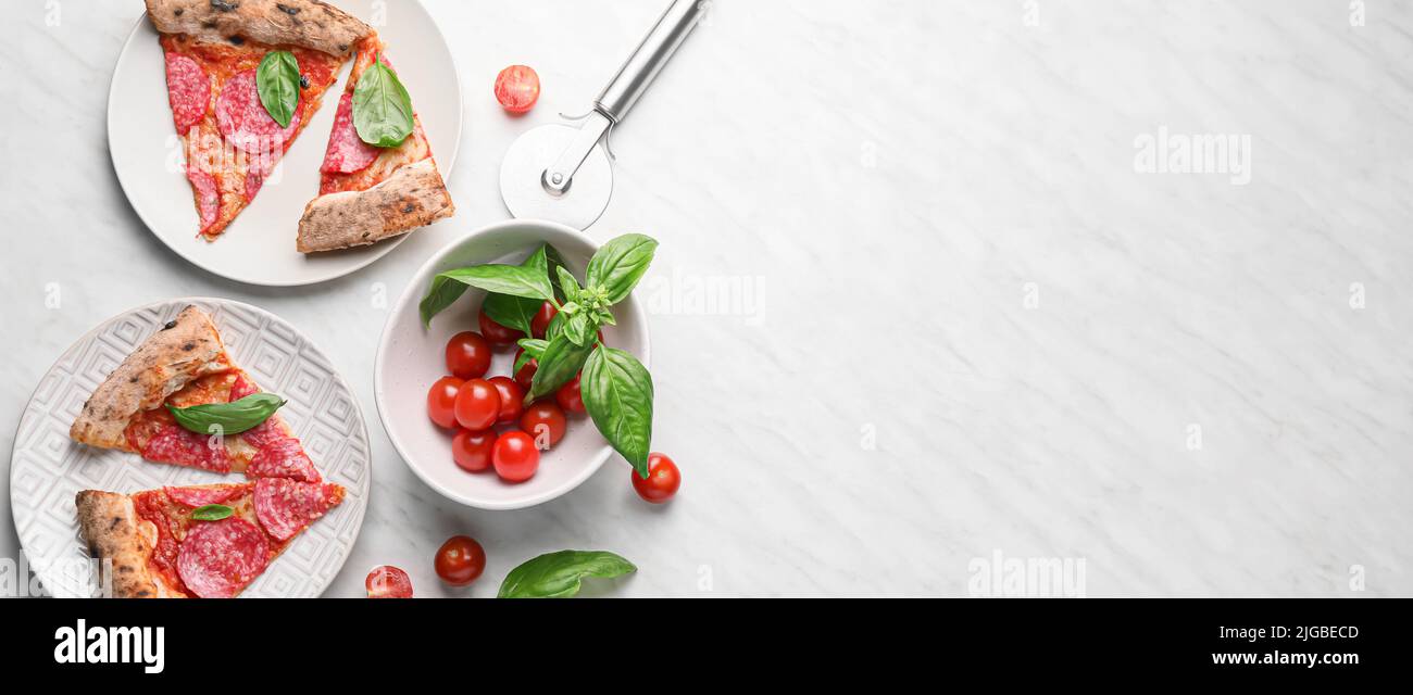 Composition with tasty cut pepperoni pizza and ingredients on light ...