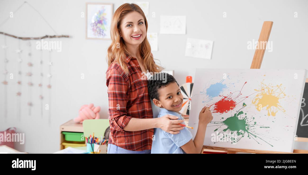 Drawing teacher and cute little student painting at school Stock Photo ...