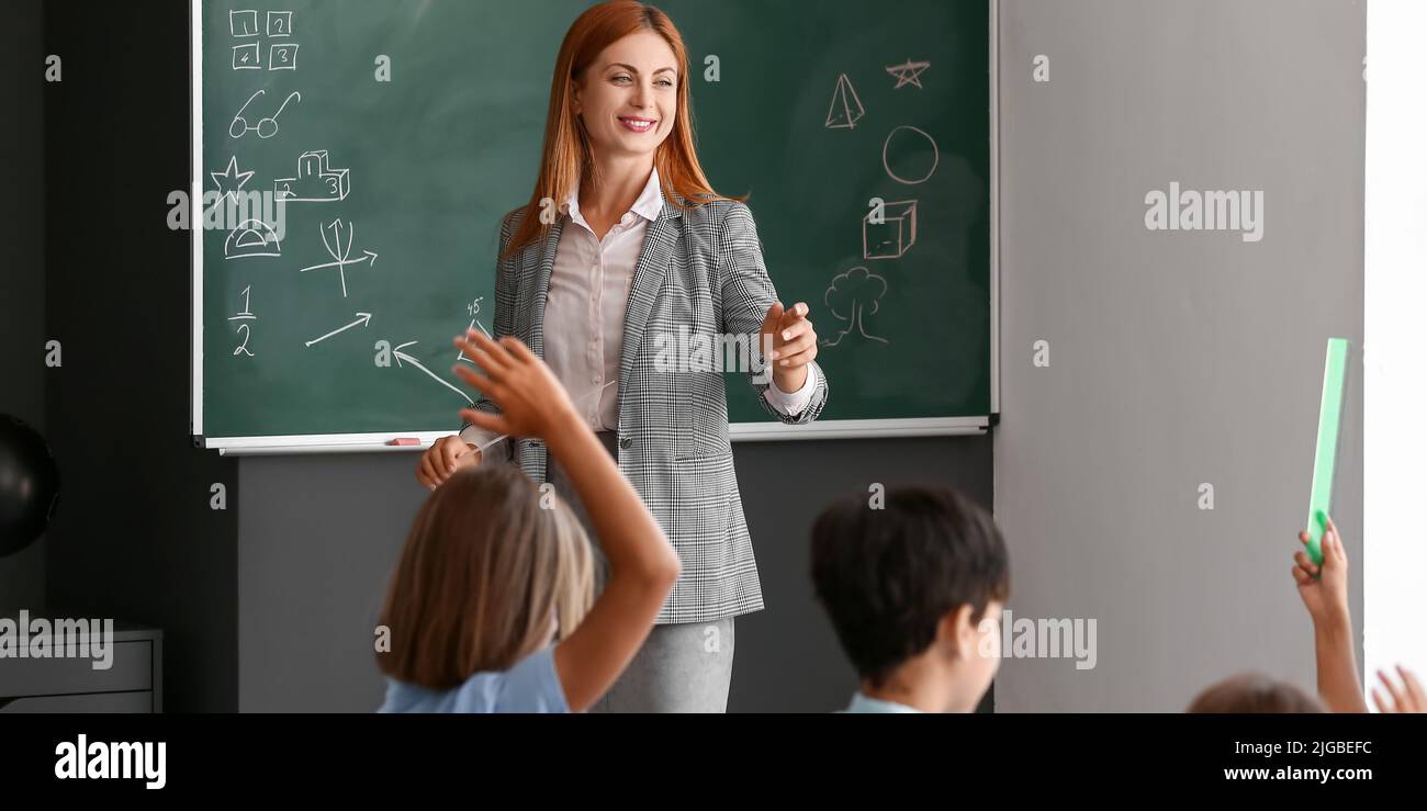 Female teacher conducting lesson in classroom Stock Photo - Alamy