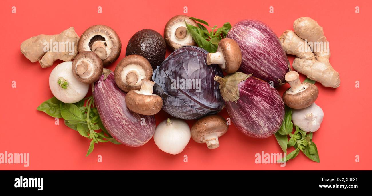 Assortment of fresh vegetables and mushrooms on red background Stock ...