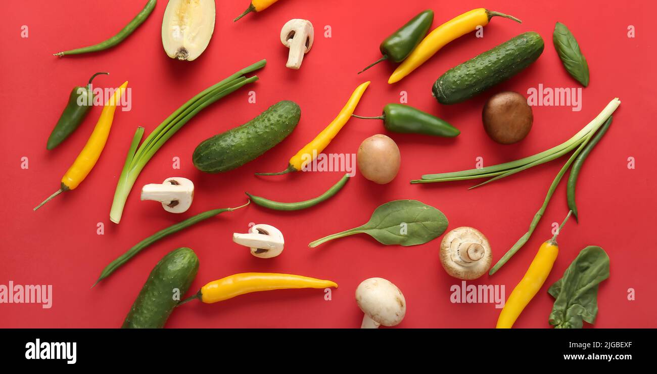 Different fresh vegetables and mushrooms on red background Stock Photo ...