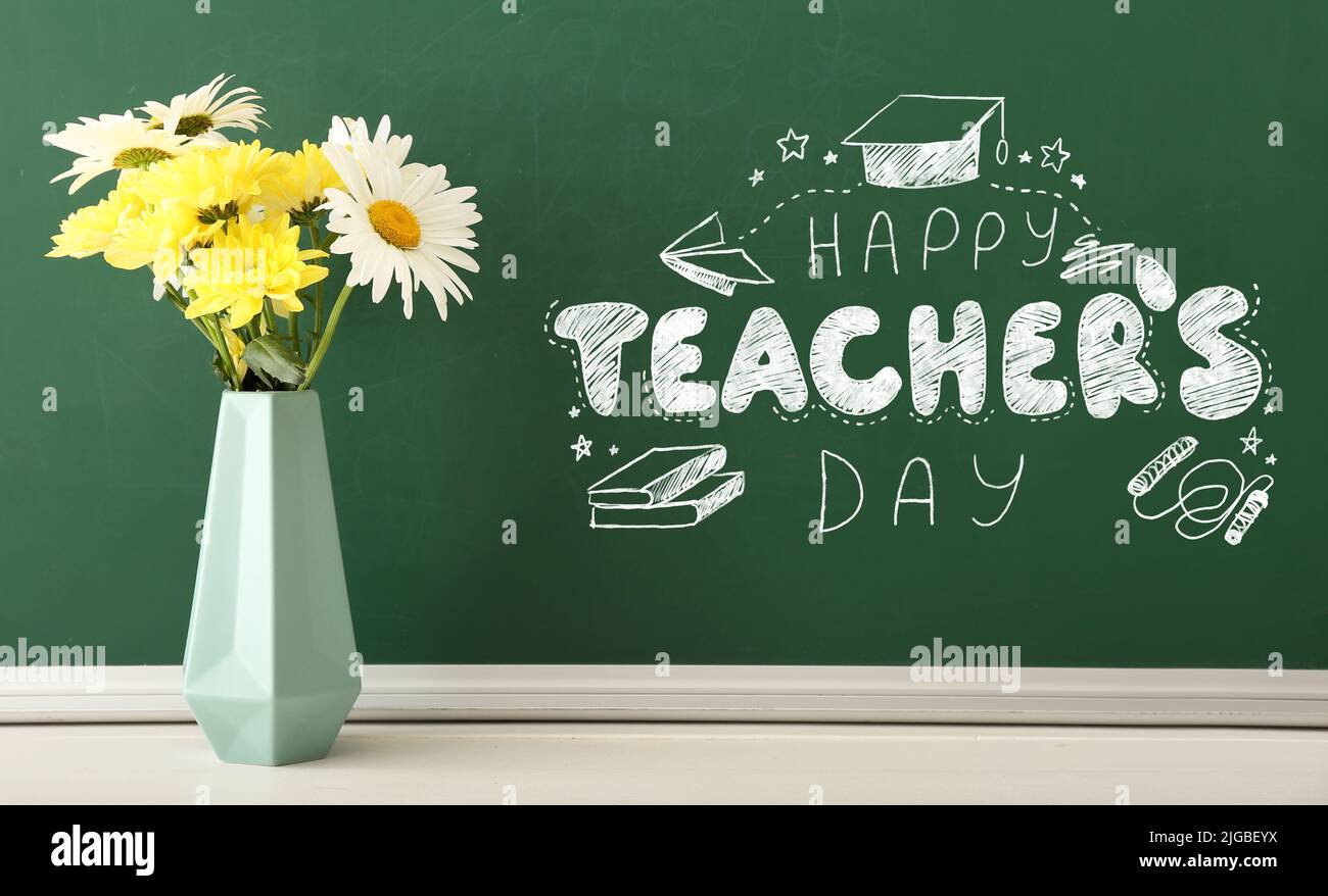 Vase with flowers on table in classroom. Teacher's Day celebration ...