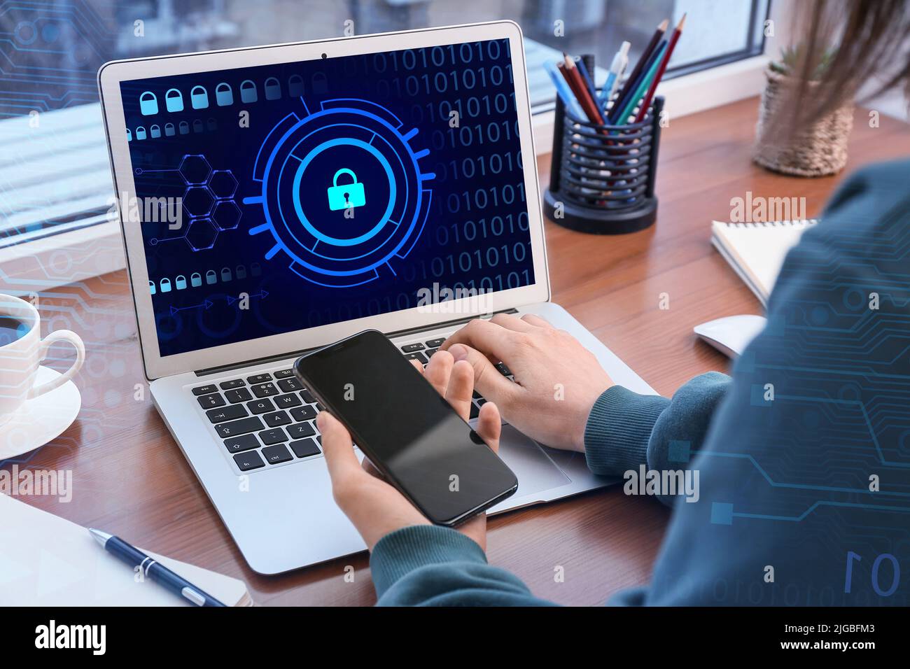 Young woman using phone and laptop with locked screen at table. Concept ...