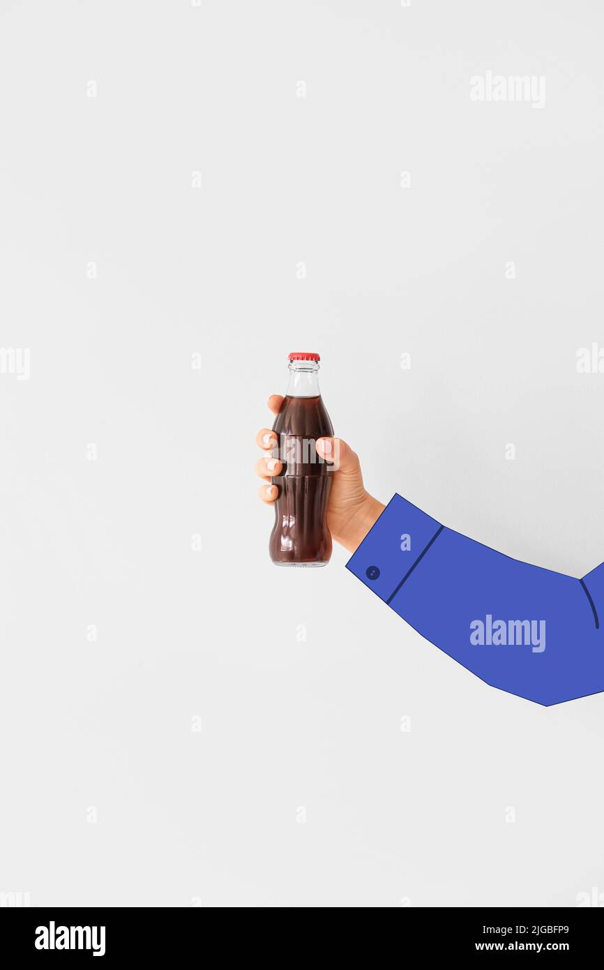 Female hand with bottle of cold cola on light background Stock Photo ...