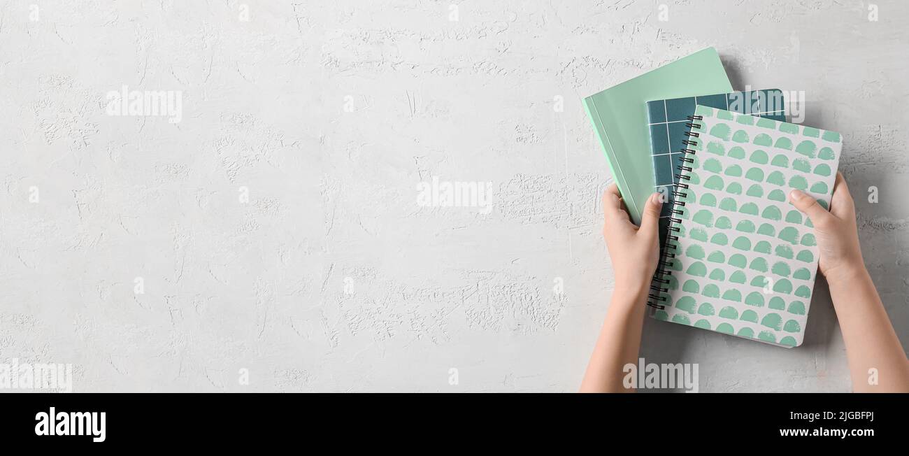 Child's hands with different notebooks on light background with space ...