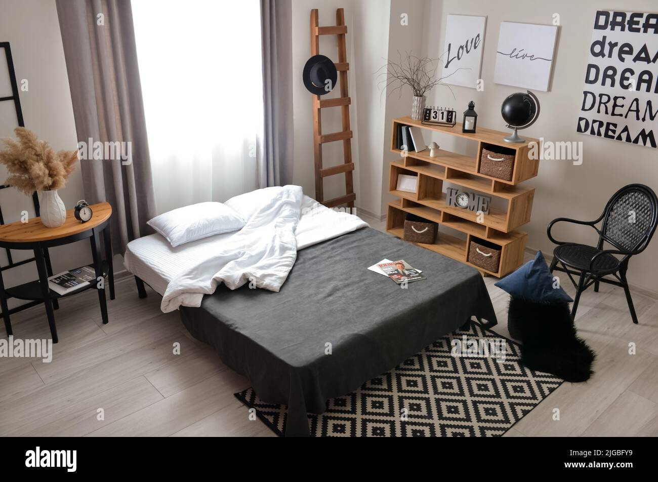 Interior of stylish bedroom with ladder and shelving unit Stock Photo ...