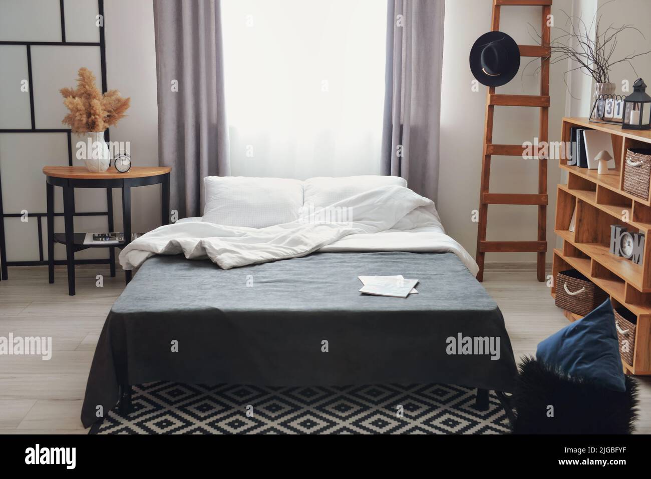 Interior of stylish bedroom with ladder and shelving unit Stock Photo ...