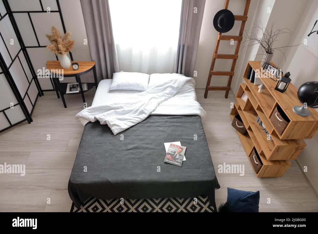 Interior of stylish bedroom with ladder and shelving unit Stock Photo ...