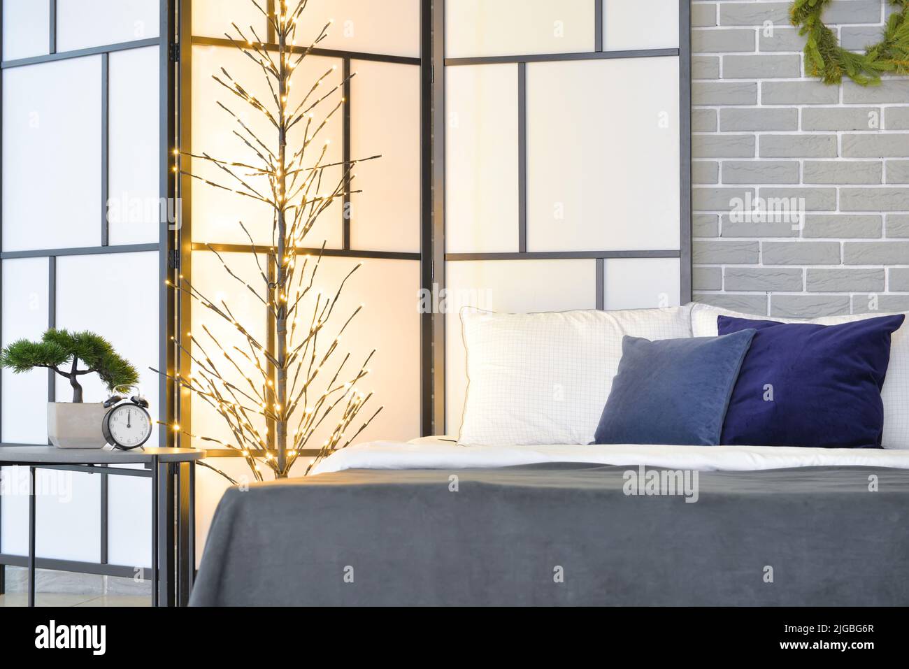 Interior of stylish bedroom with folding screen and glowing lights ...