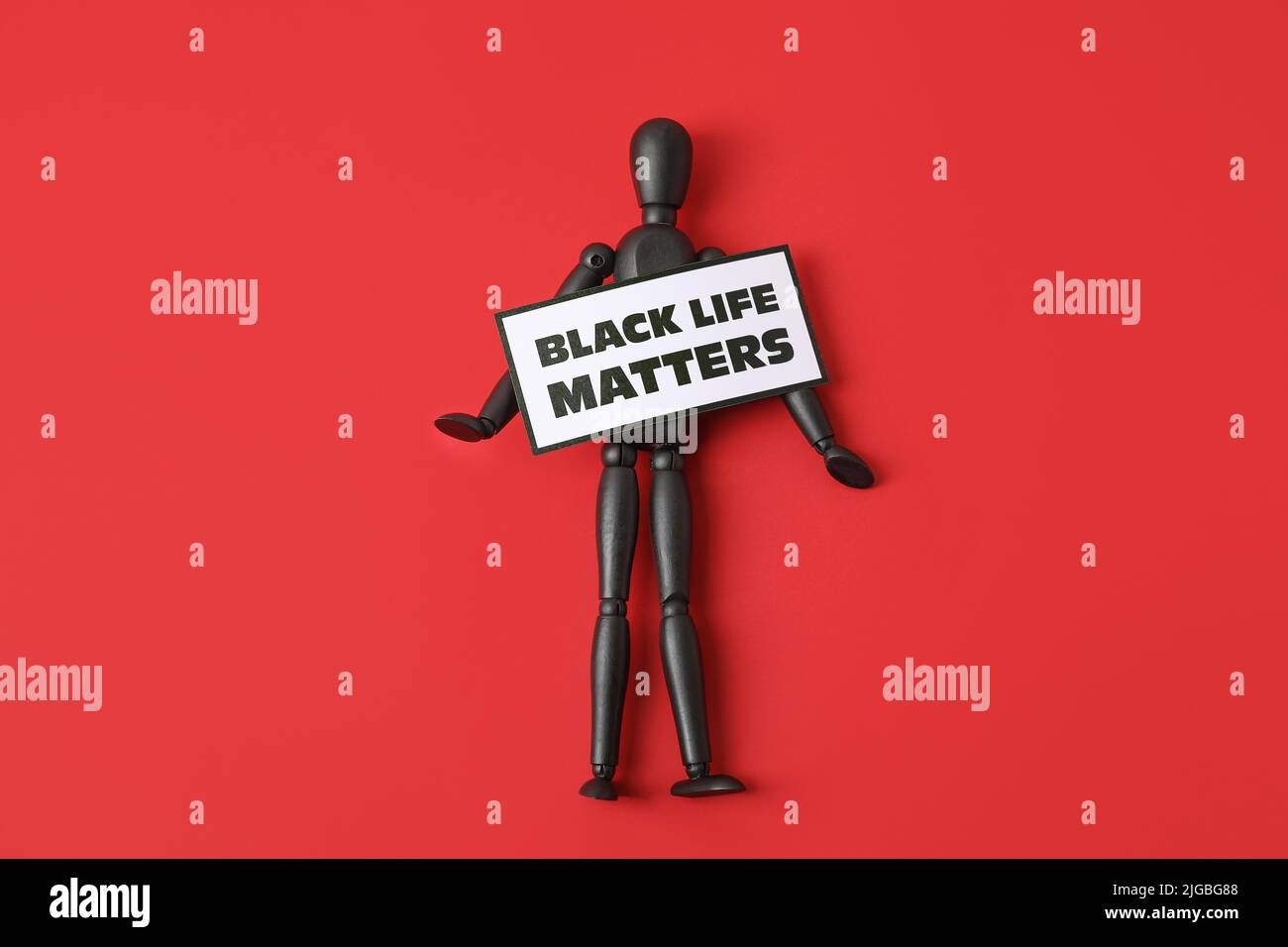 Black mannequin and paper sheet with text BLACK LIFE MATTERS on color ...