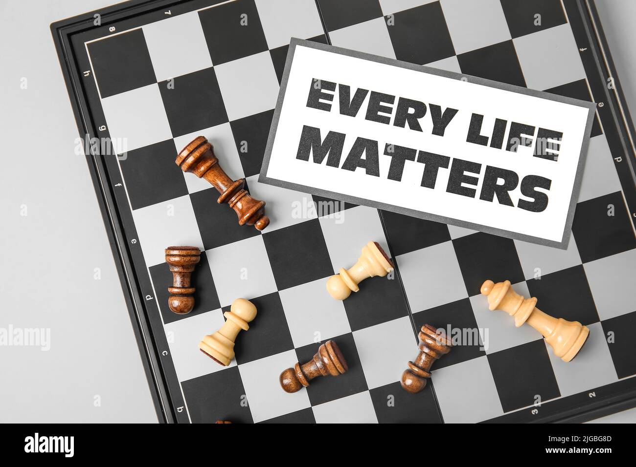 Board, chess pieces and paper sheet with text EVERY LIFE MATTERS on ...