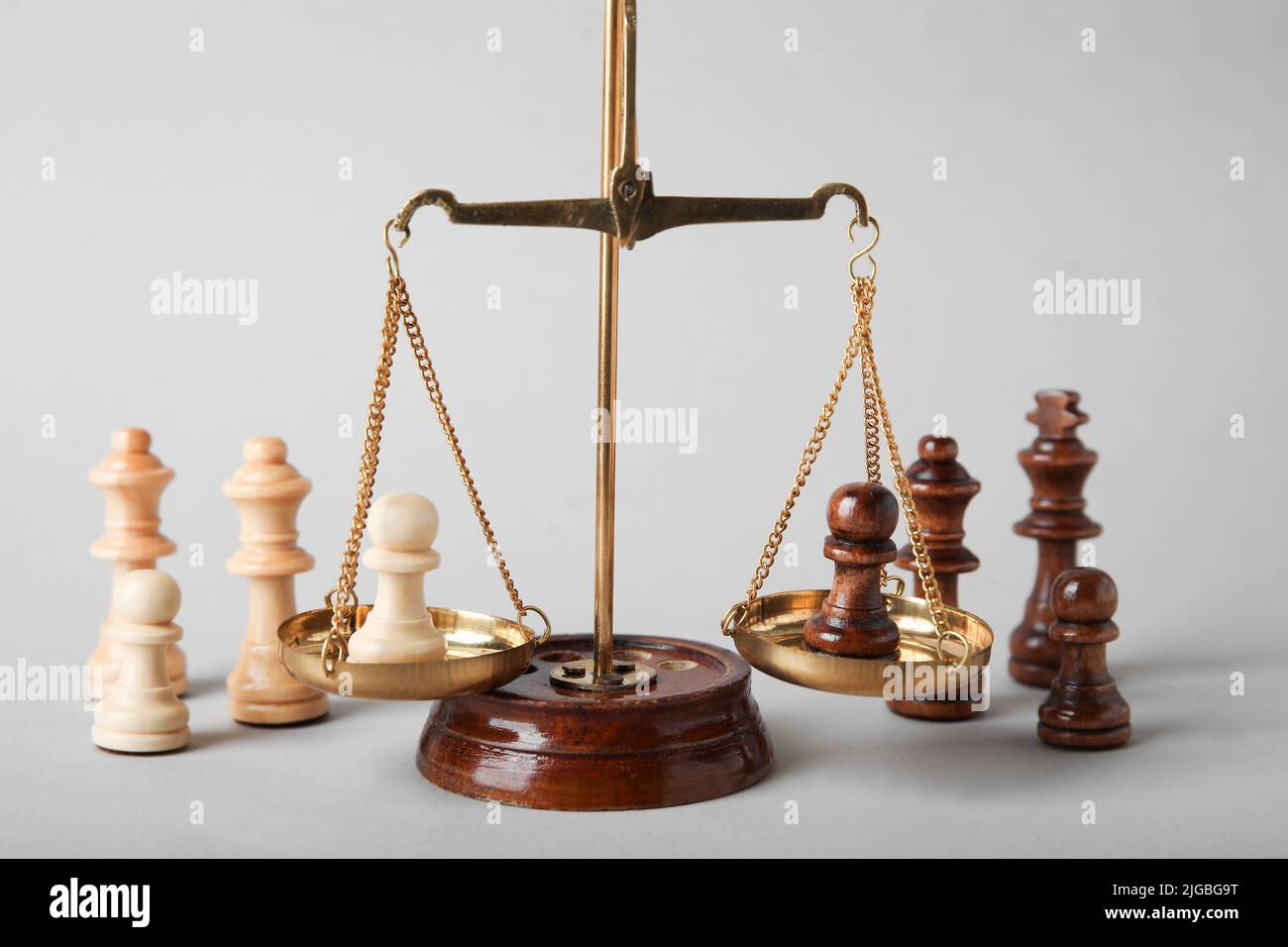 Chess pieces and scales on grey background Stock Photo - Alamy