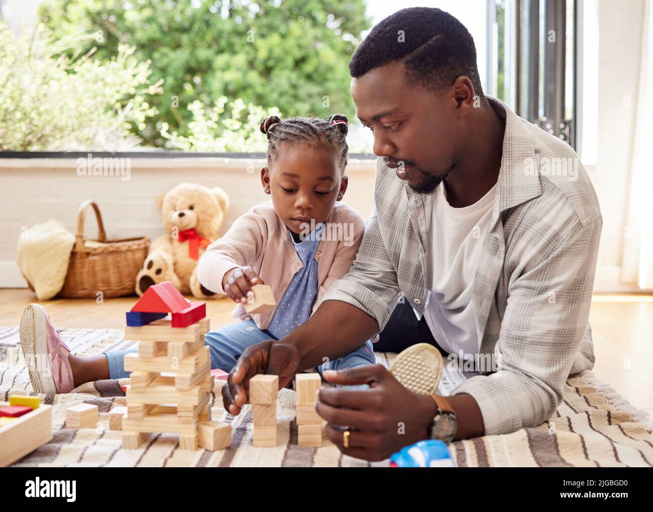 Lets build a house. a little girl playing with blocks with her father ...
