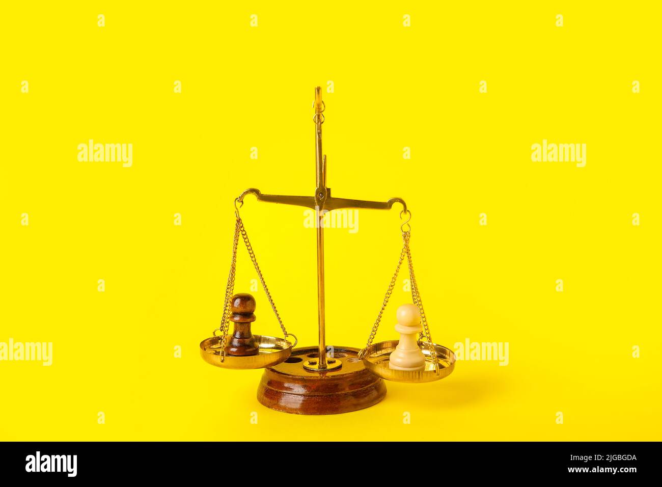 Chess pieces and scales on yellow background Stock Photo - Alamy