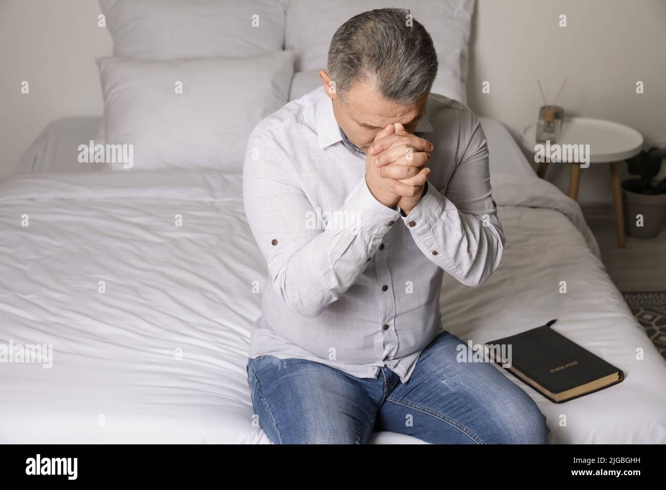 Man in bed praying hi-res stock photography and images - Alamy
