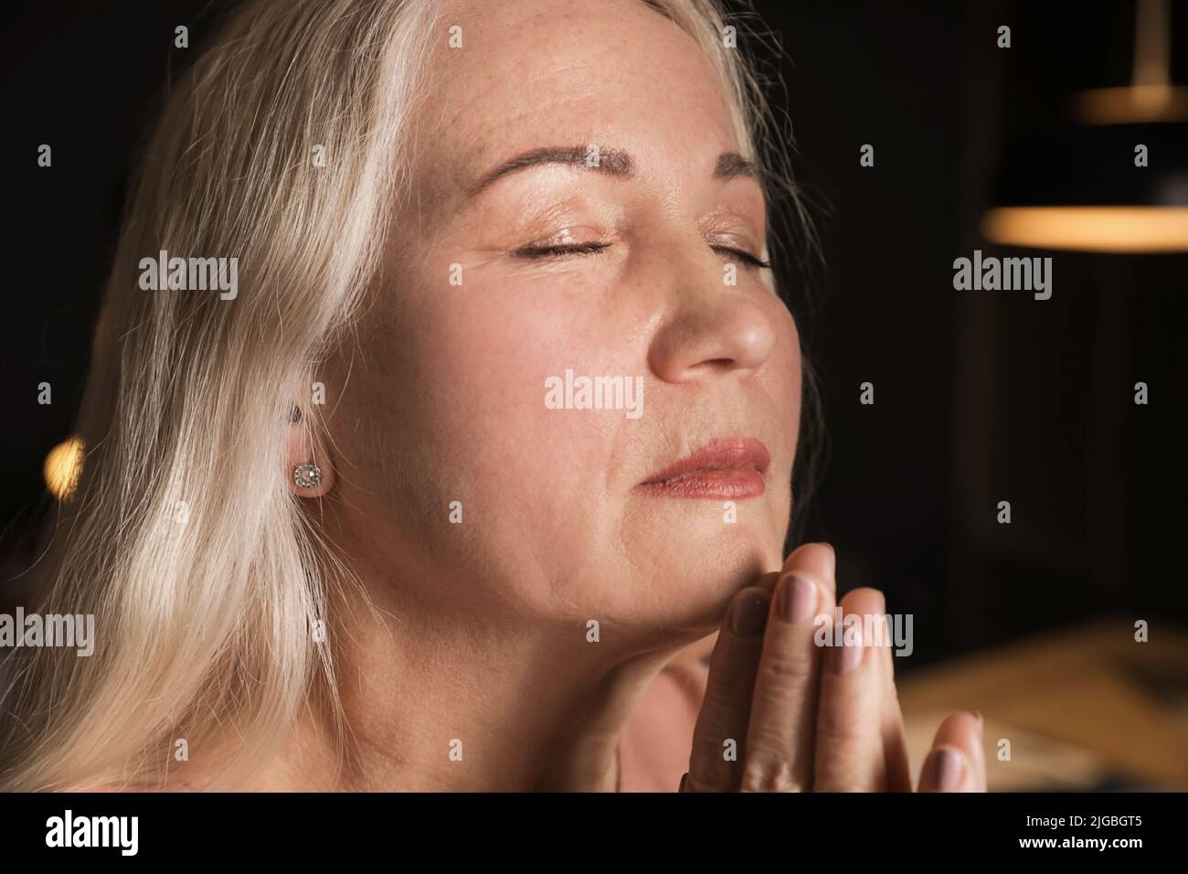 Woman praying in dark room hi-res stock photography and images - Alamy