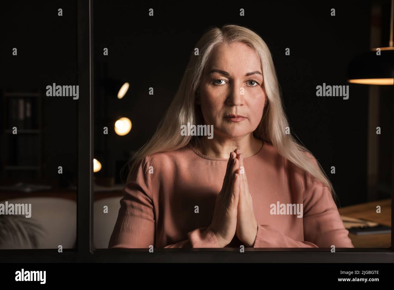 Praying woman in dark room hi-res stock photography and images - Alamy