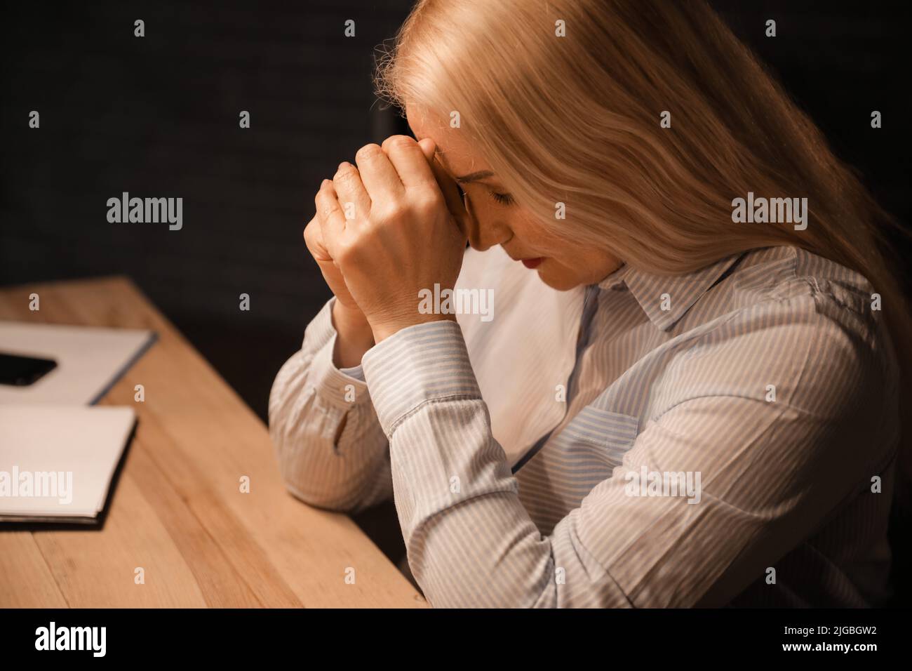 Praying woman in dark room hi-res stock photography and images - Alamy