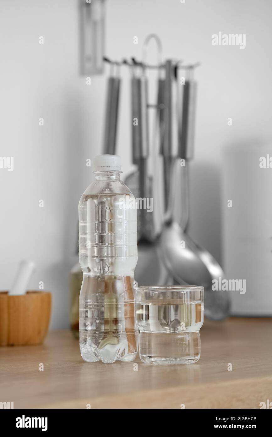 Plastic bottle and glass of clean water on kitchen counter Stock Photo ...