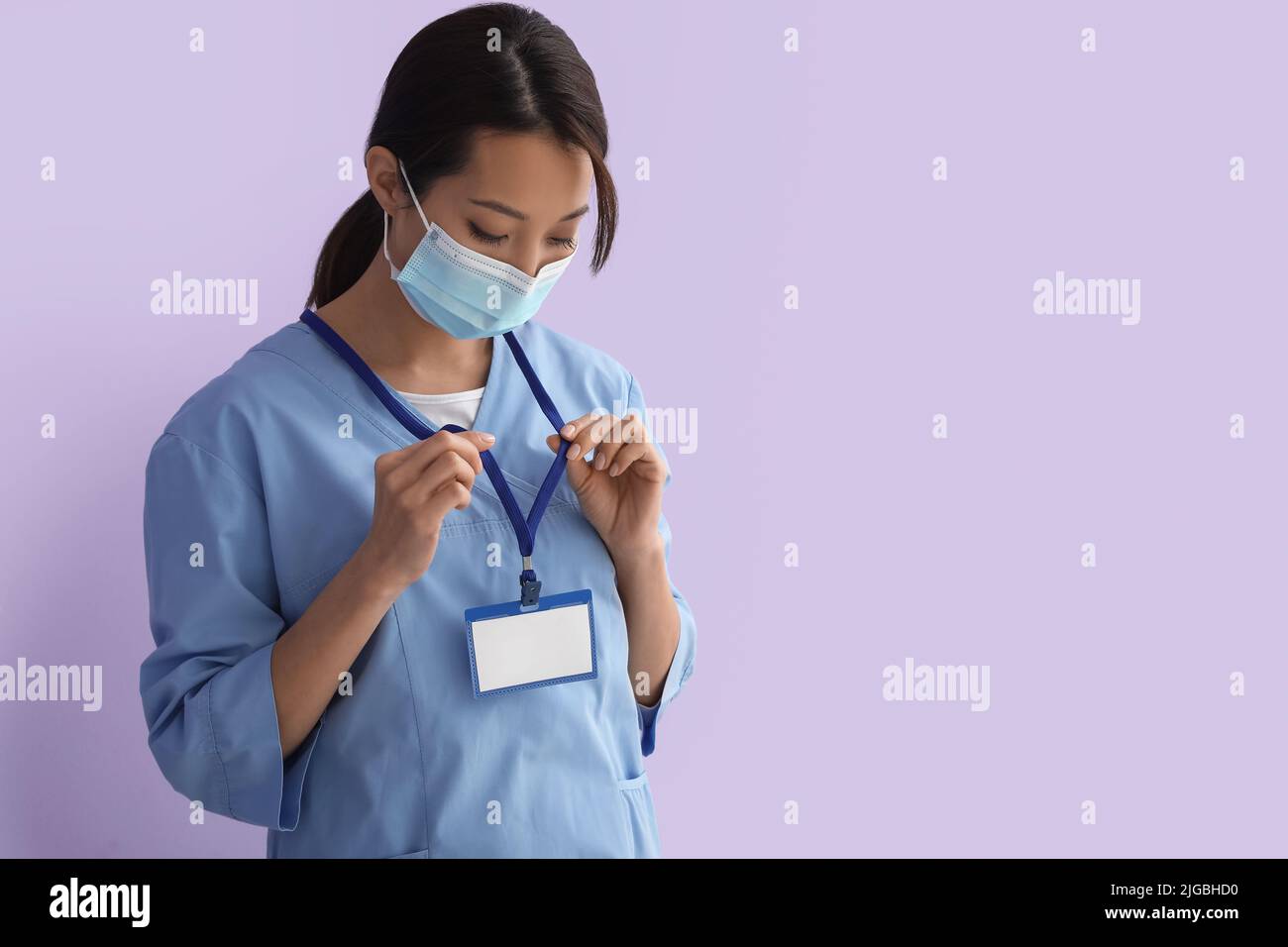 Female Asian nurse with badge on color background Stock Photo - Alamy