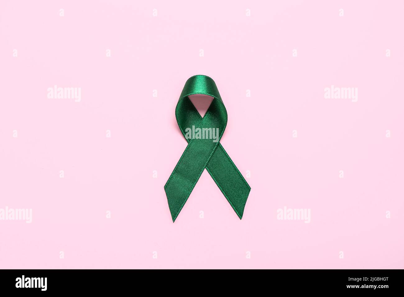 Green ribbon on pink background. Liver cancer concept Stock Photo - Alamy